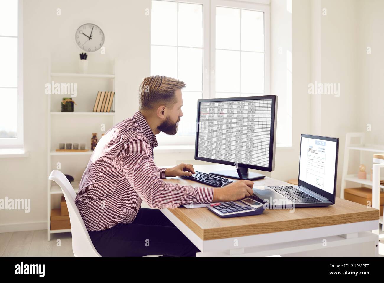 Accountant sitting at office desk and working with spreadsheets and ...