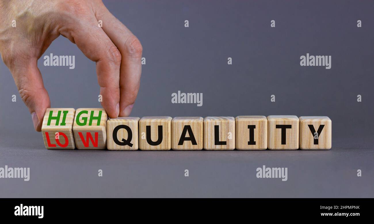 Low or high quality symbol. Businessman turns cubes and changes words ...