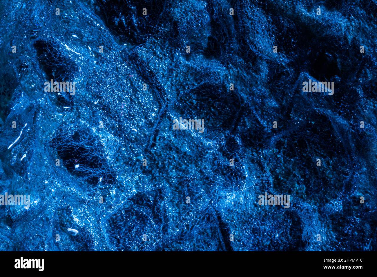 Photo of dark blue toned frozen wooden coal covered in ice surface ...