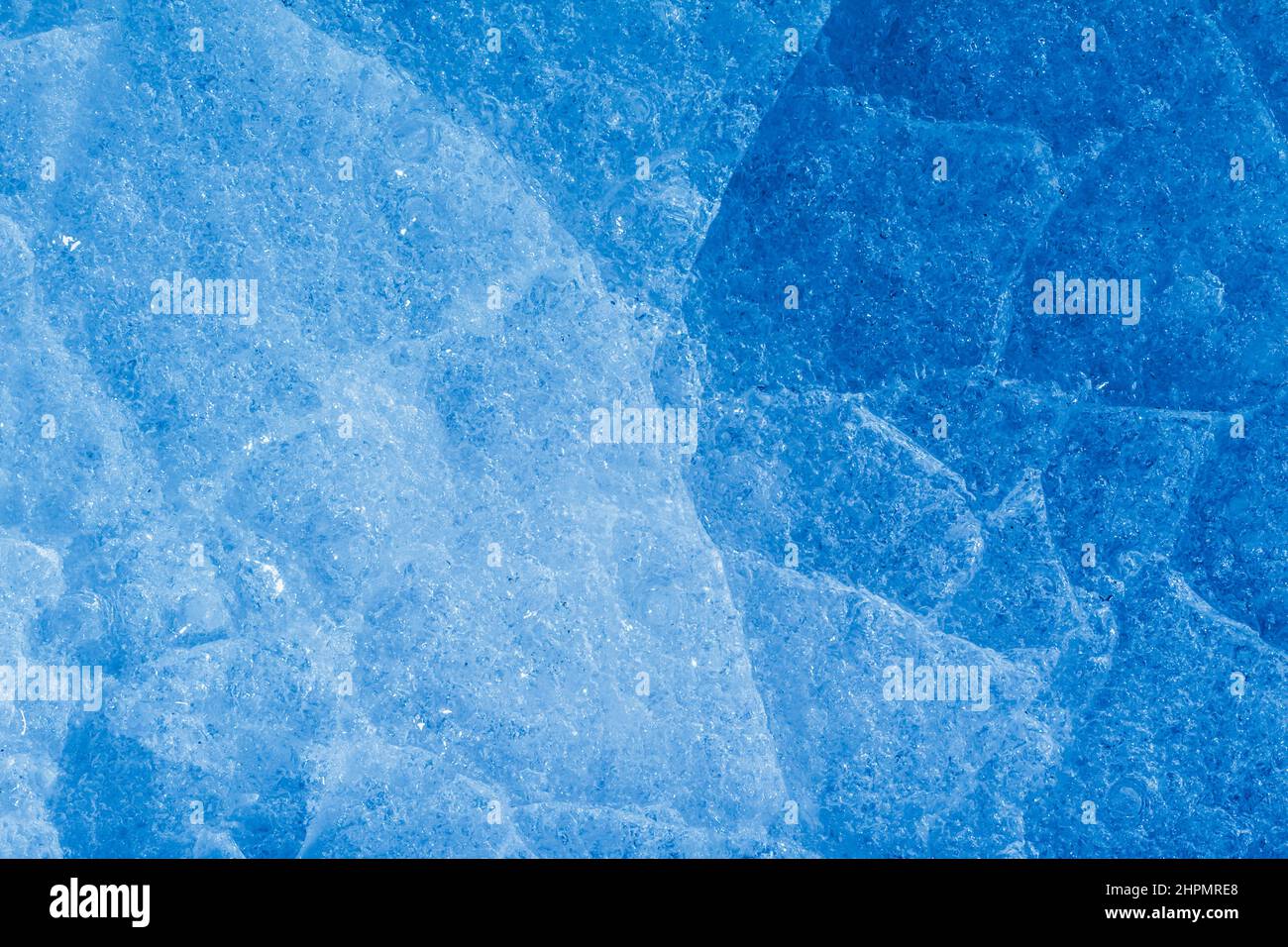 Photo of light blue toned frozen cracked ice with snow surface texture ...