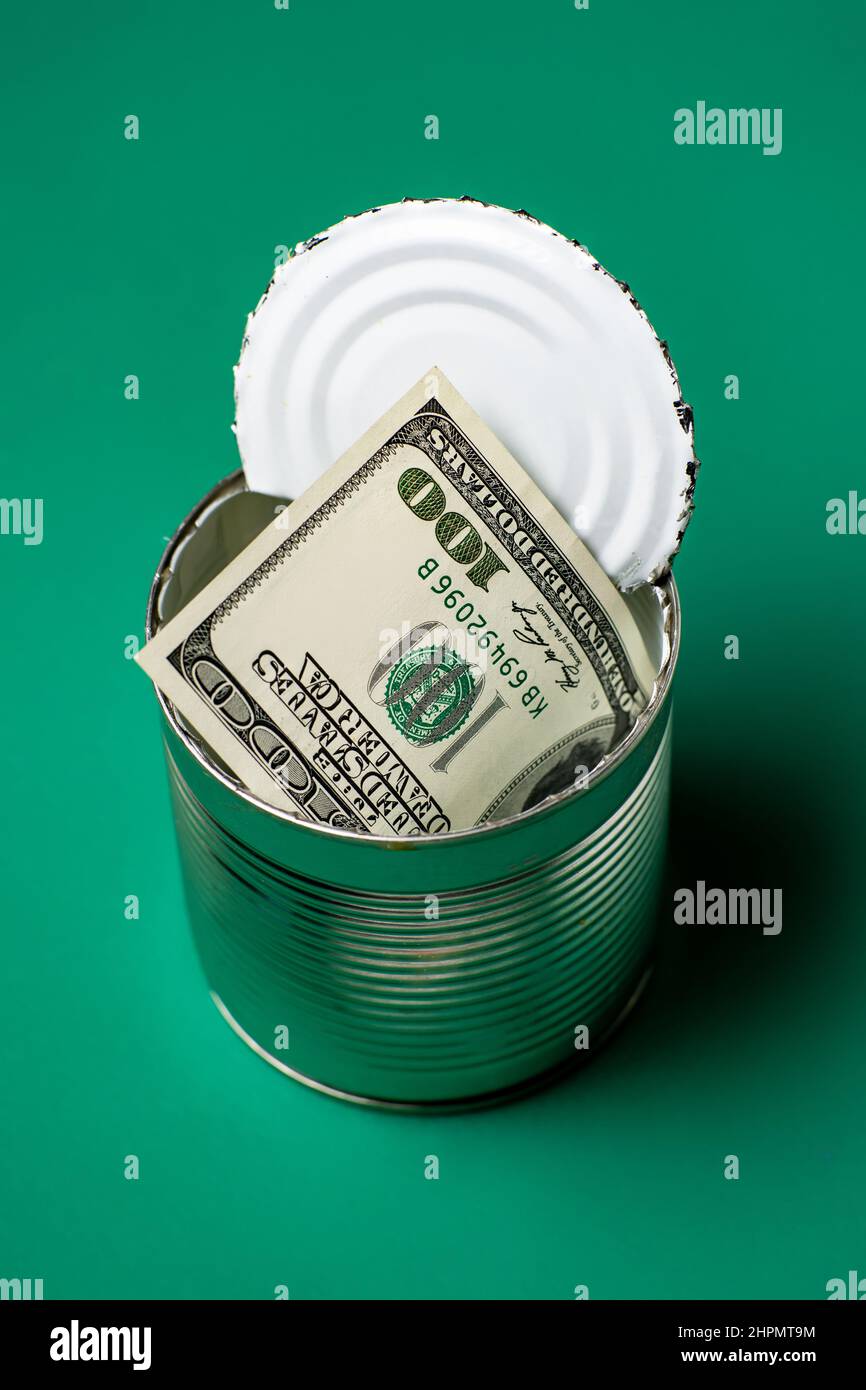 Dollars in an open tin can. Safeguarding cash, stash concept. Time to ...