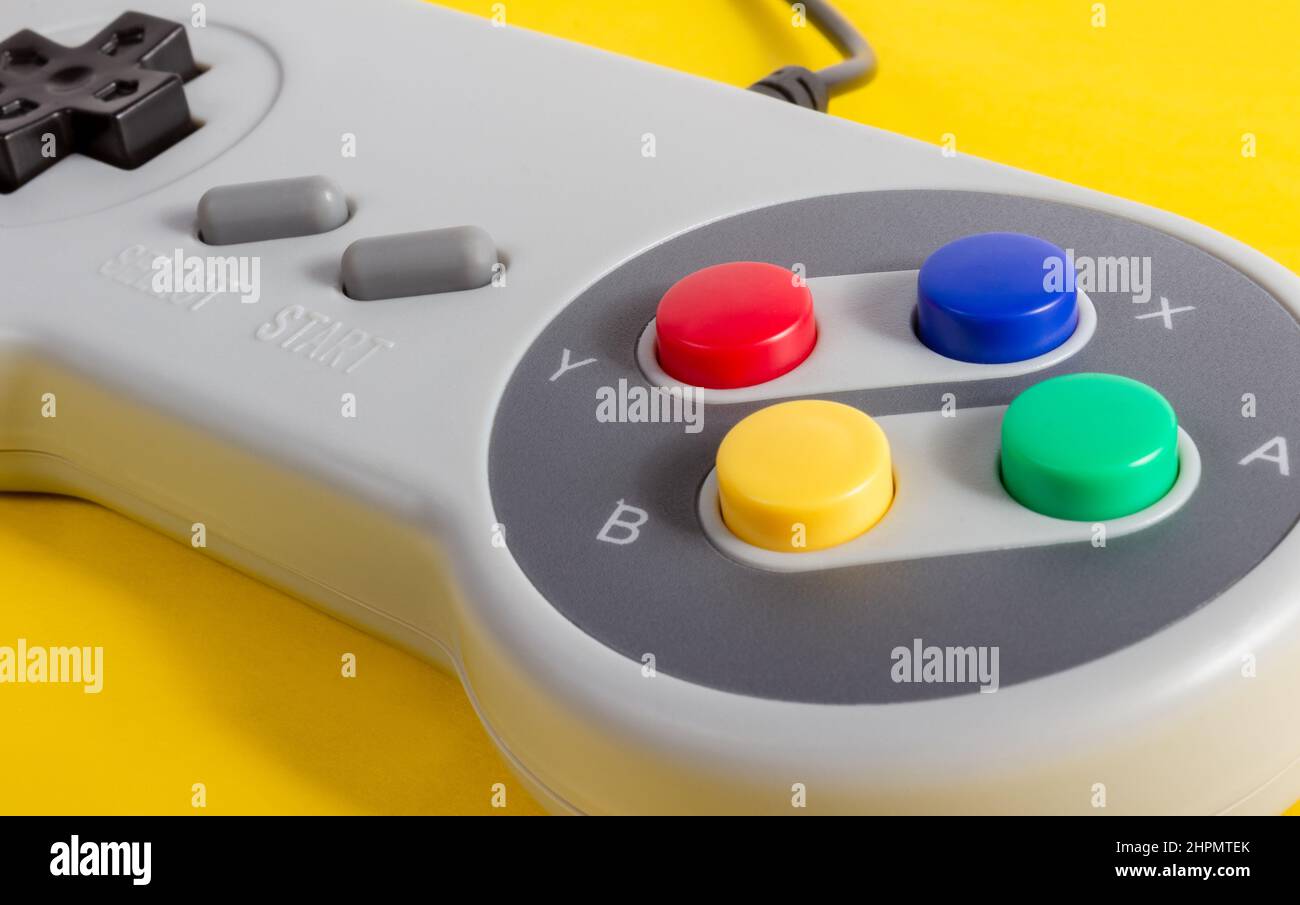 Close up photo of classic gray colored 8 bit game pad controller laying ...