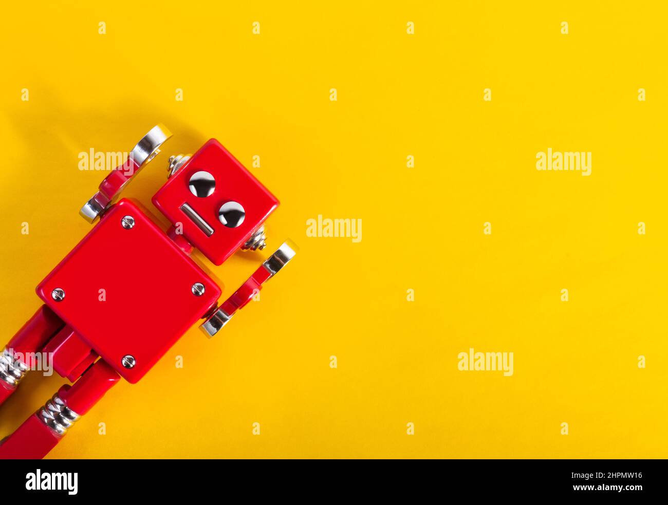 Photo of red colored metal robot toy miniature sticking out on orange ...