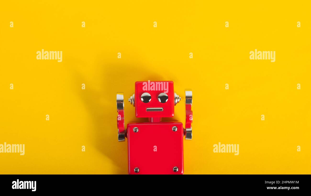 Photo of red colored classic metal robot toy miniature laying on orange ...