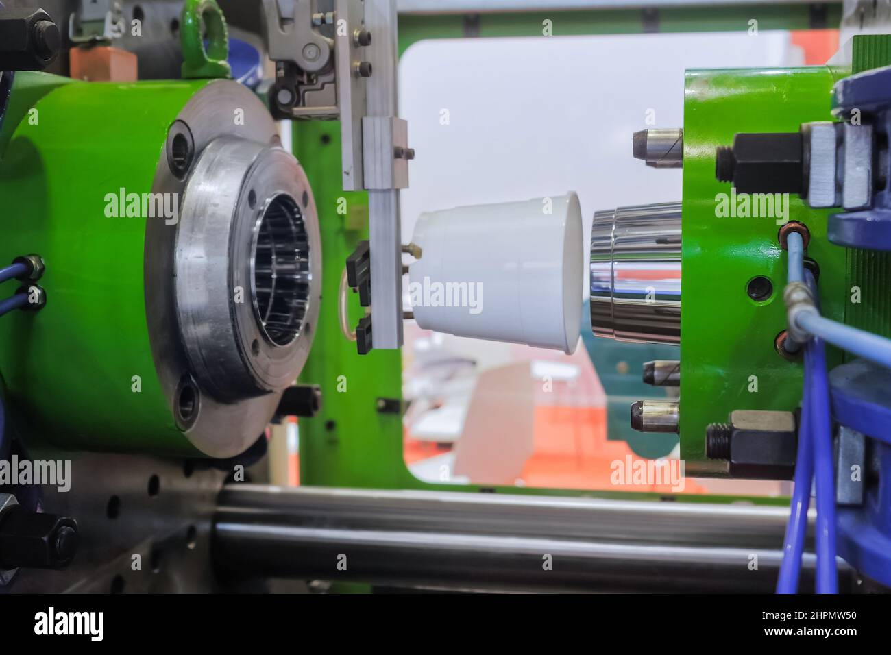 Injection molding machine during work: production of empty plastic pots ...