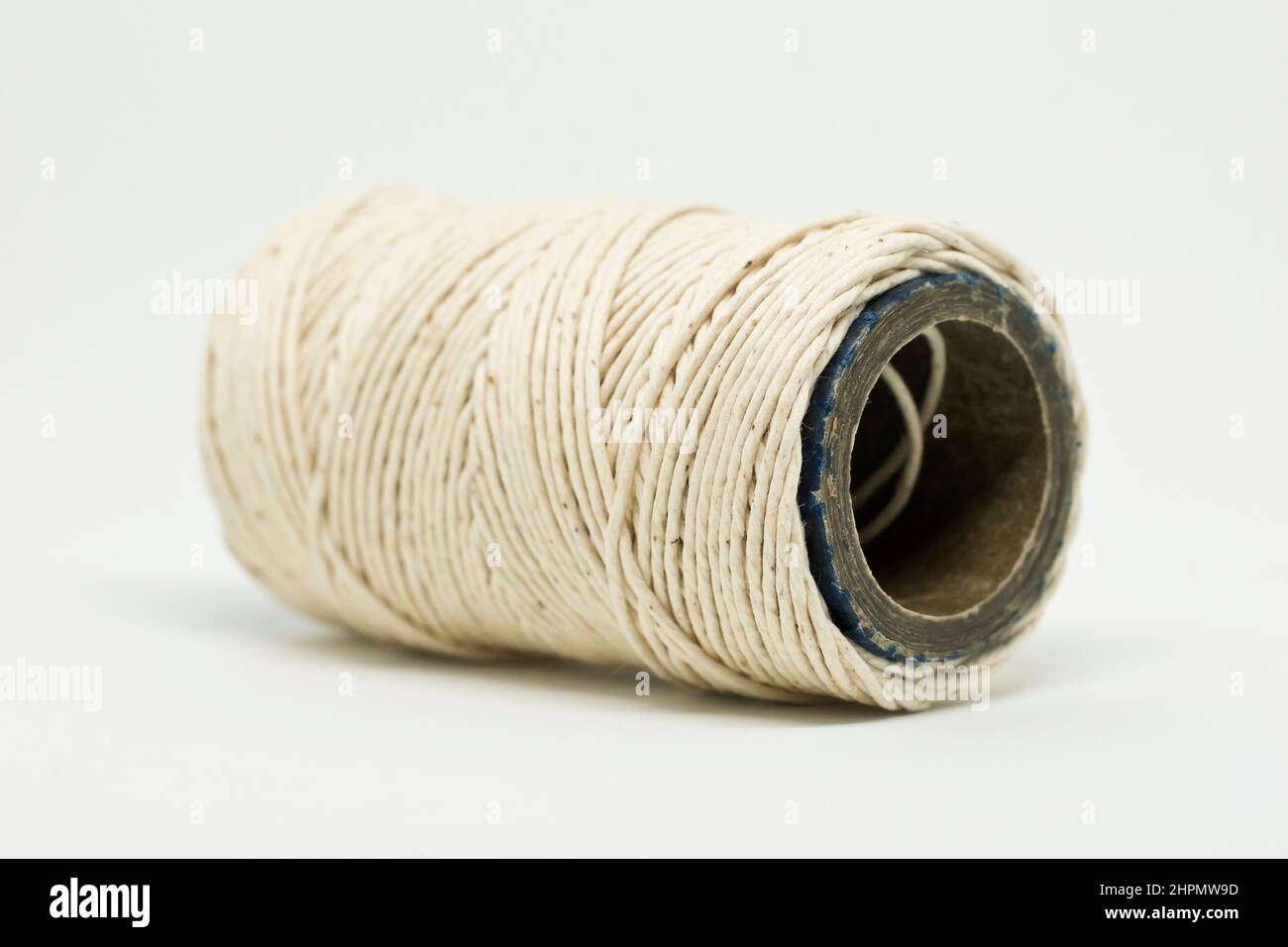 Close up of a single spool of white cotton string, isolated against a ...