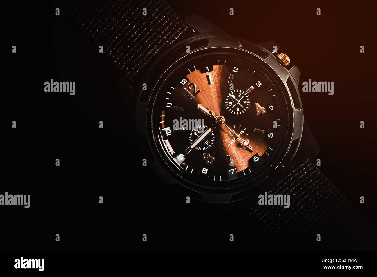 Shaded photo of military tactical watch with copper elements on black ...