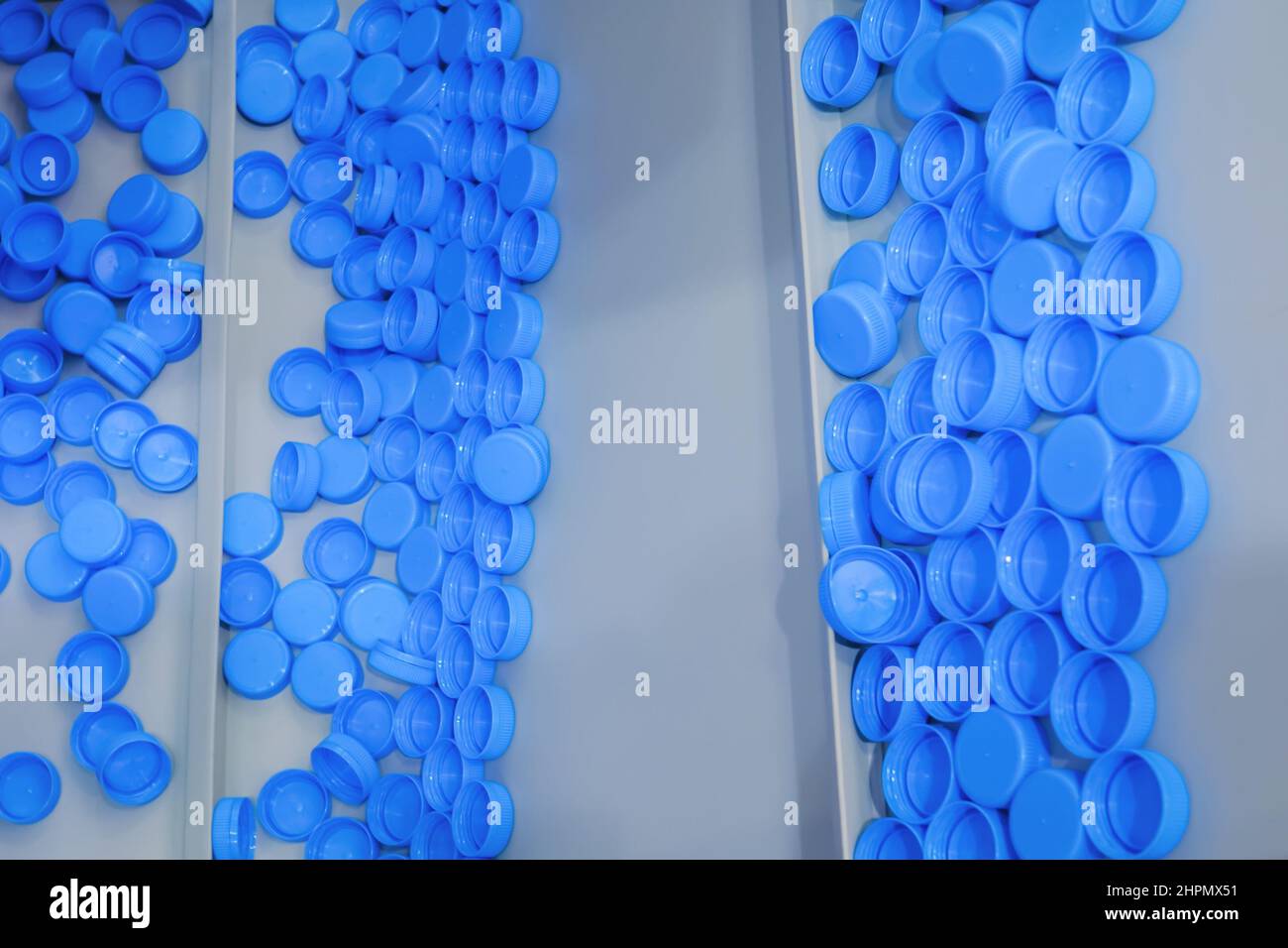 Many blue plastic bottle caps moving on conveyor belt - production line ...
