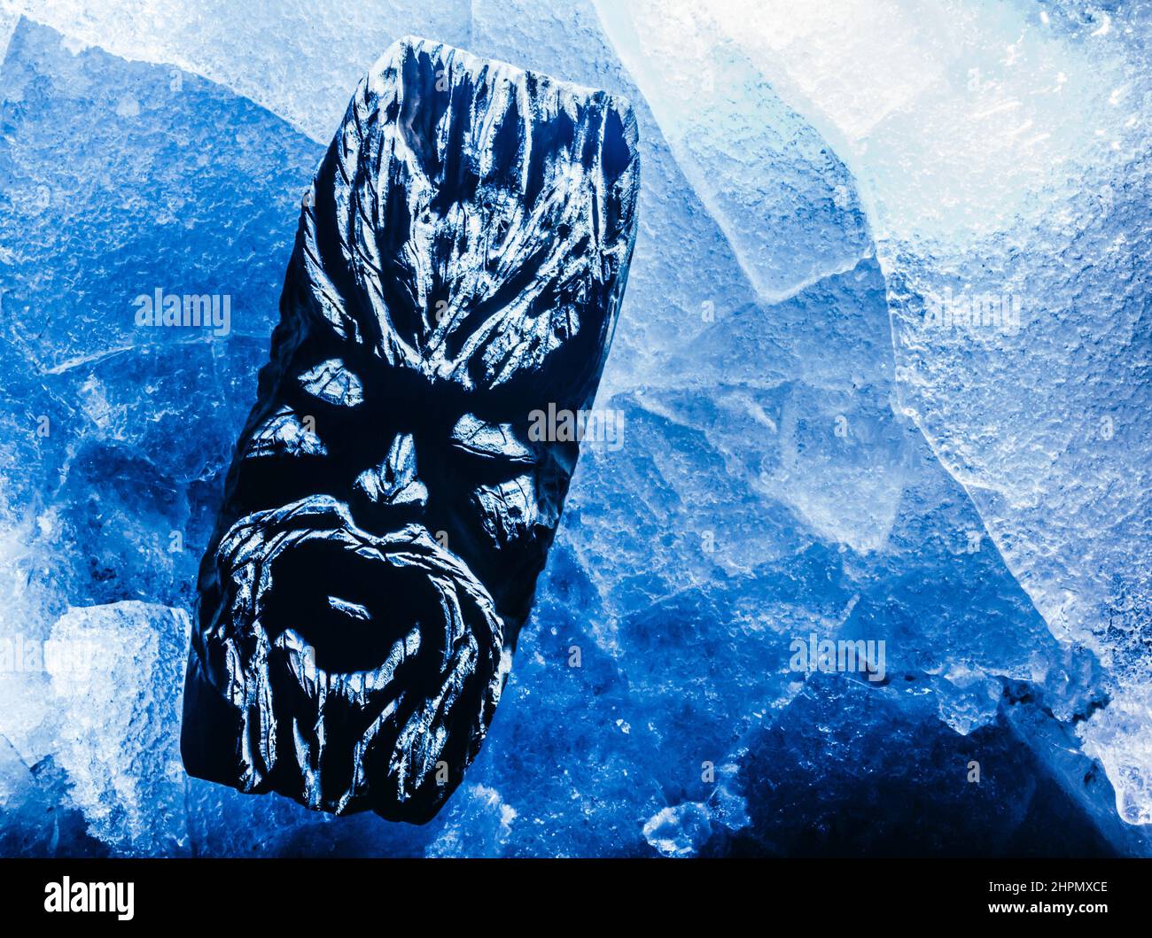 Photo of blue toned ancient wooden fantasy face idol totem laying on ...