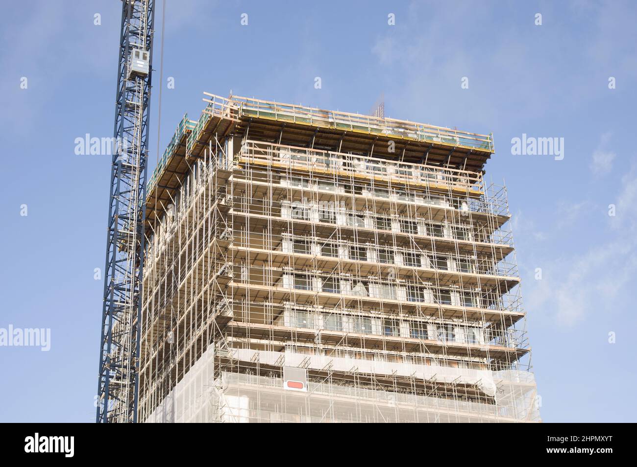 Large residential tower under construction with large blue crane n ...