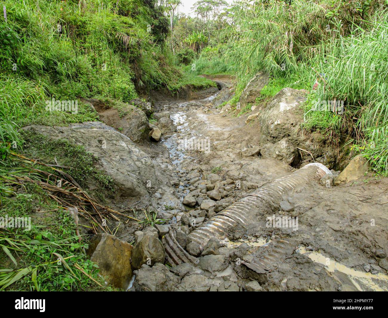 Washed out road in the mountains of Papua New Guinea, packed dirt has ...