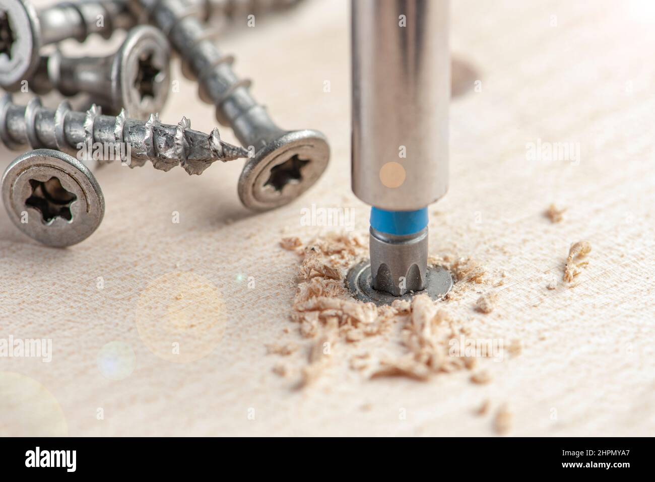 Screw the screw into the board. Furniture production, a screwdriver ...