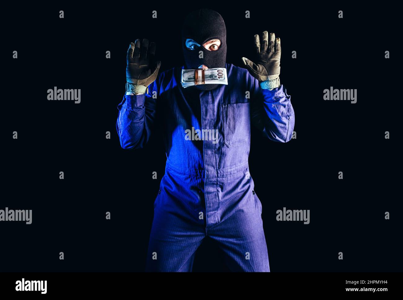 Photo of caught robber in mask, overalls, gloves putting hands up on ...