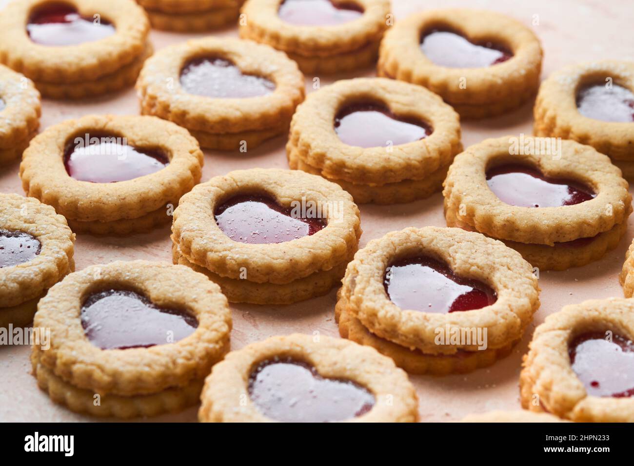 Traditional Linzer cookie with strawberry jam and powder sugar on pink ...