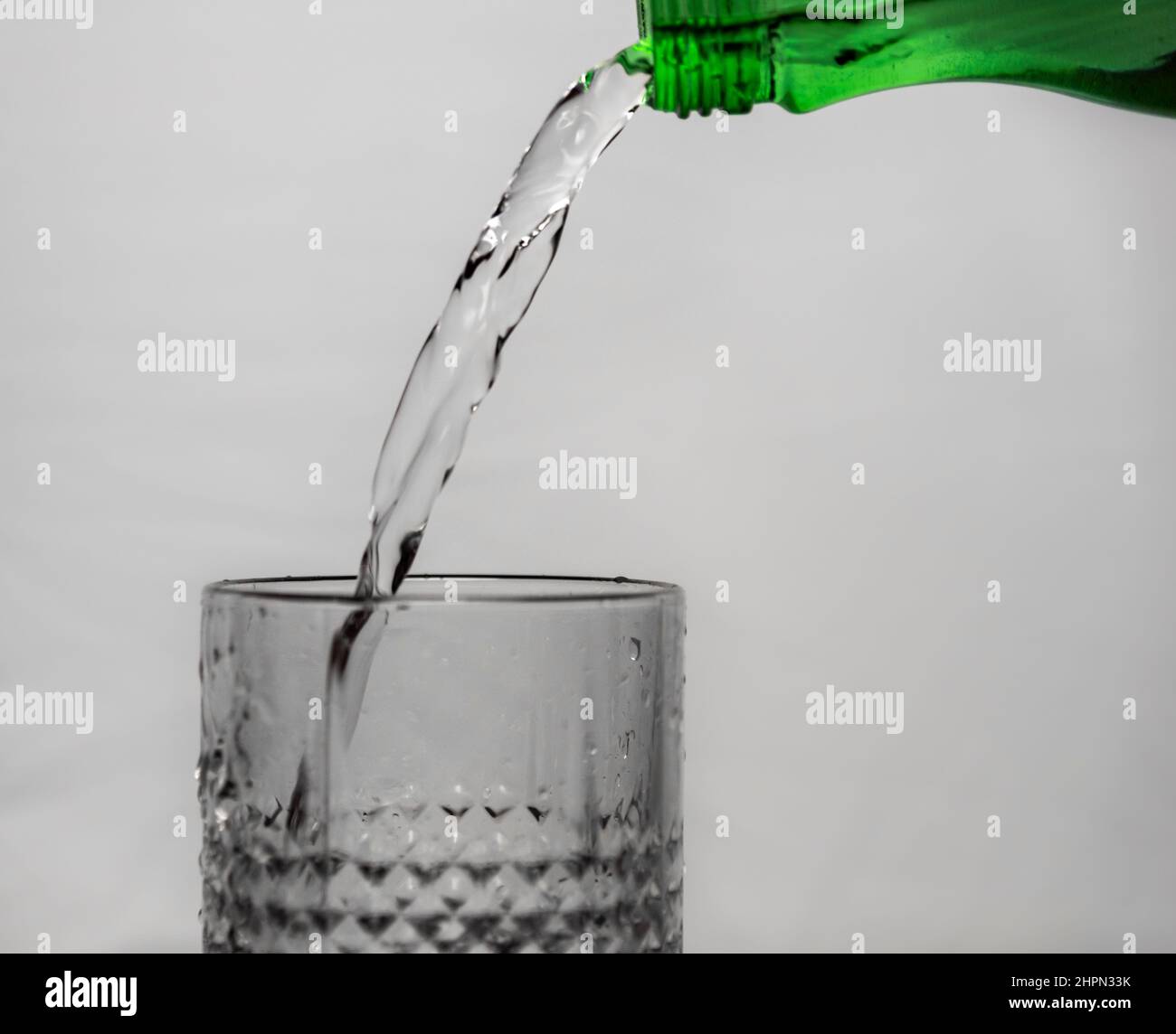Glass with running clean water and gray dark background Stock Photo - Alamy