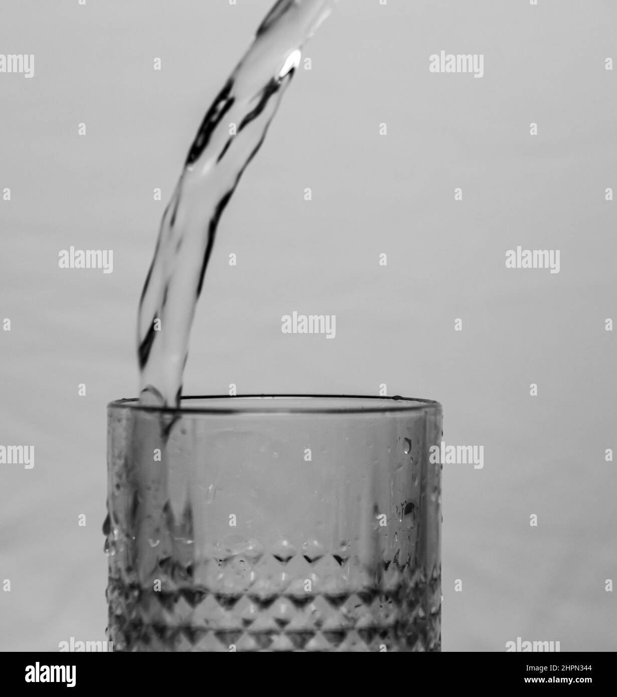 Glass with running clean water and gray dark background Stock Photo - Alamy