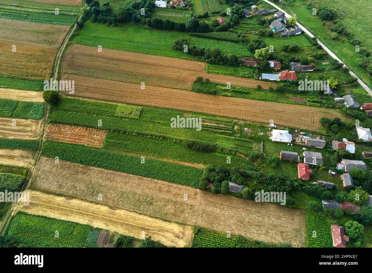 Aerial landscape view of village houses and distant green cultivated ...