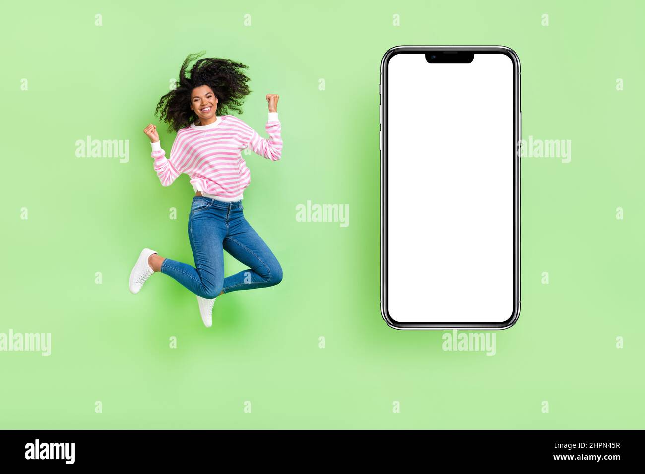 Full length view of cheerful lucky girl jump rejoice win cellphone ads ...