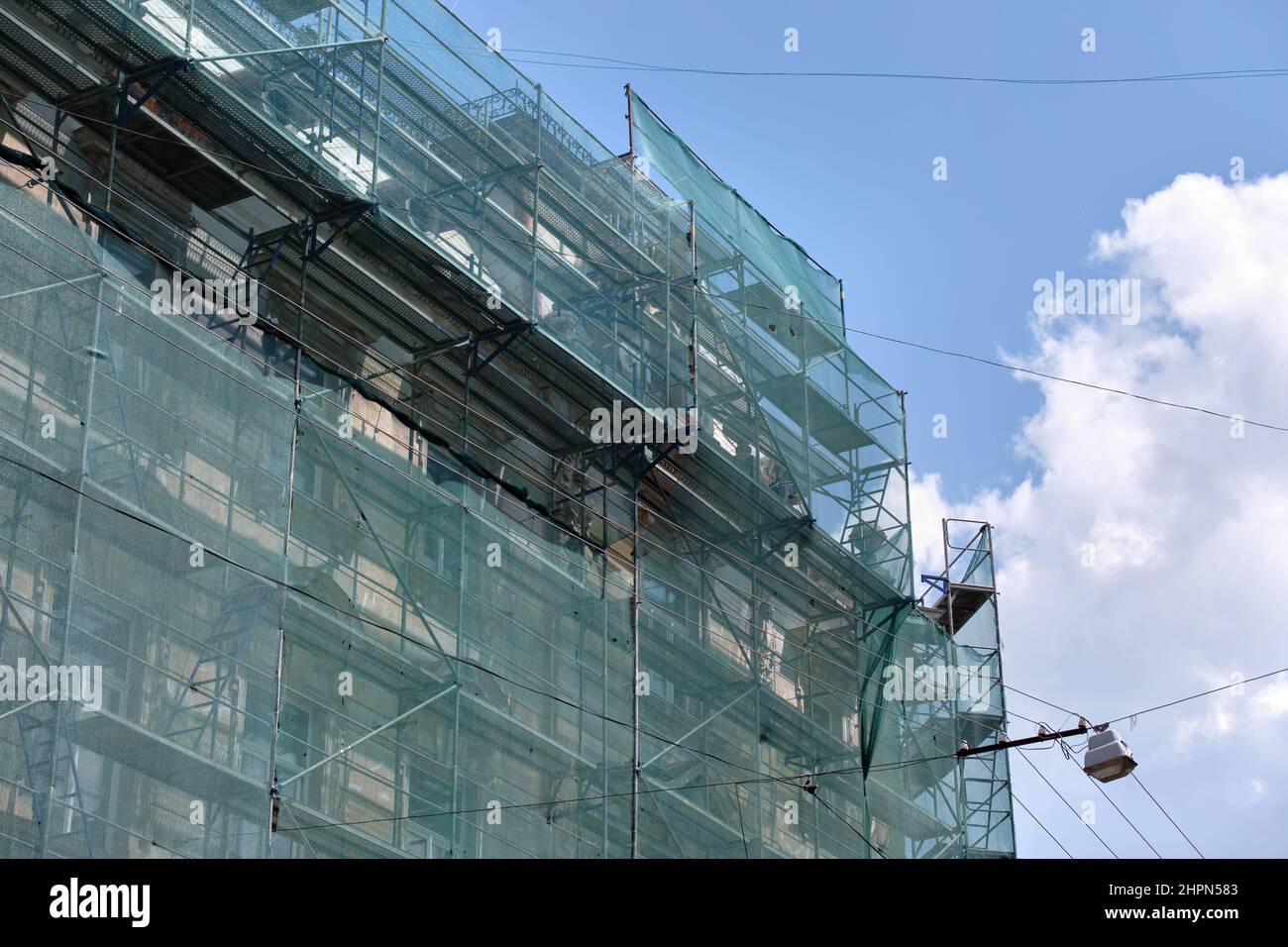 Building facade under renovation works with construction scaffolding ...