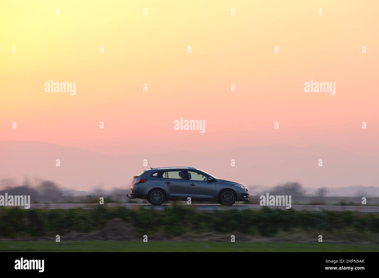 Car driving fast on intercity road at sunset. Highway traffic in ...