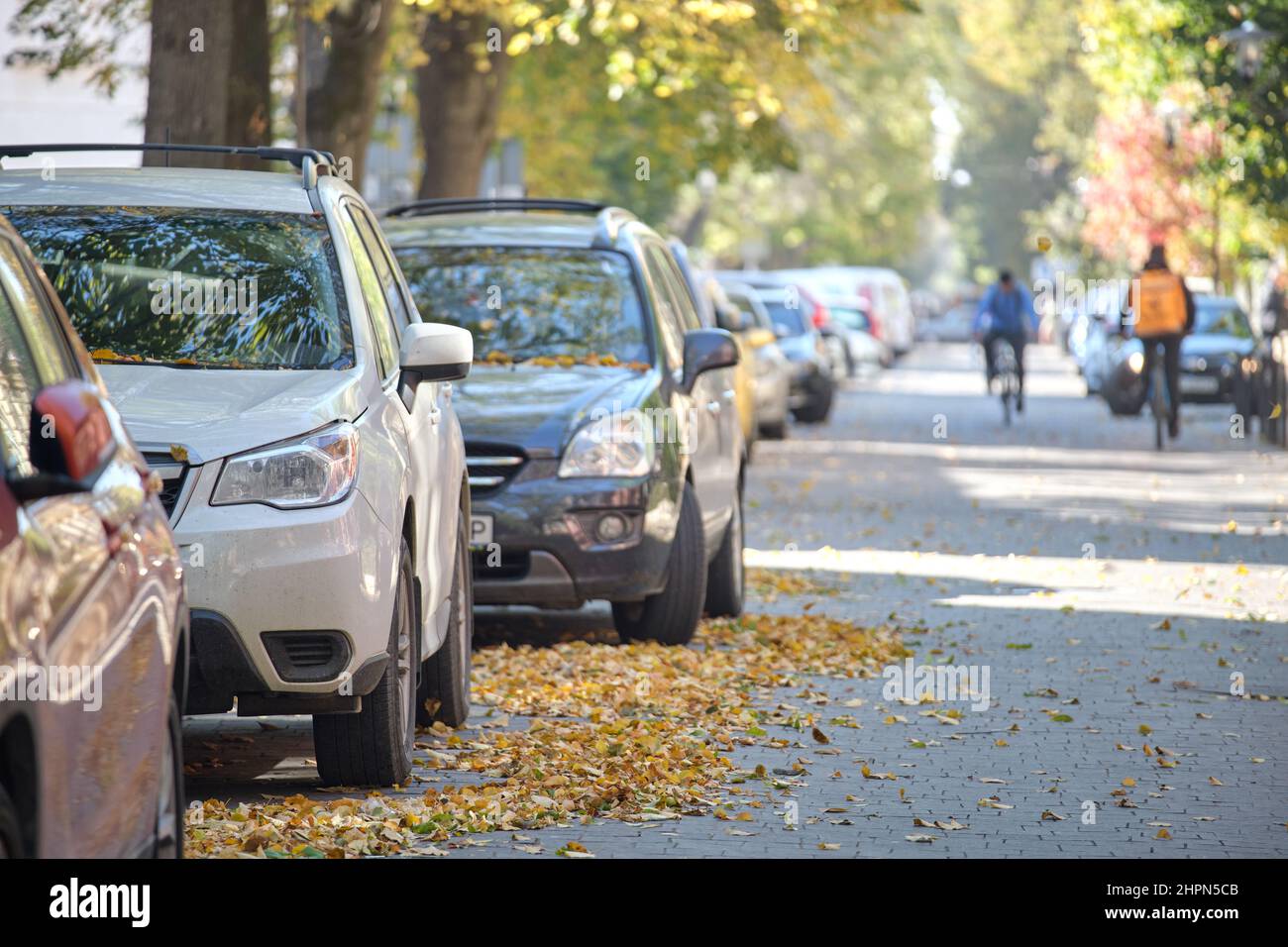 City traffic with many cars parked in line on street side Stock Photo ...