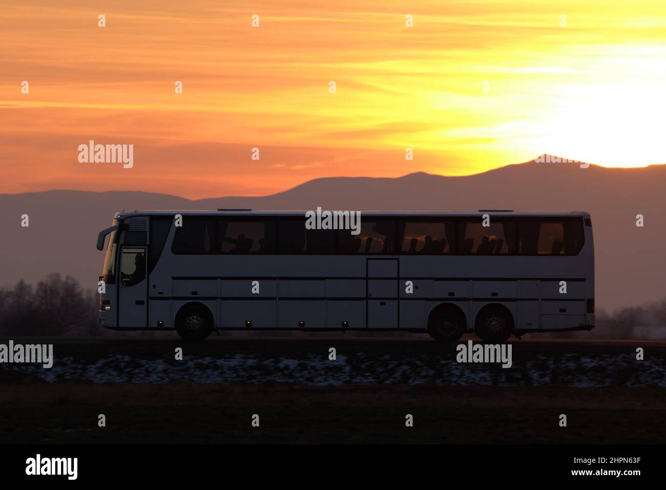 Intercity passenger bus driving on highway road in evening Stock Photo ...