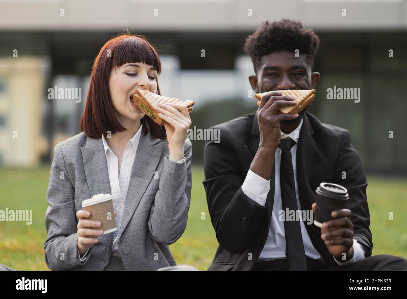 Healthy sandwich, lunch break concept. Two multiracial successful ...