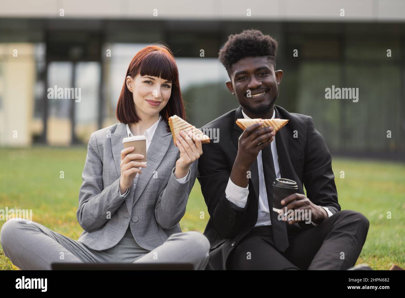 Healthy sandwich, lunch break concept. Two multiracial successful ...