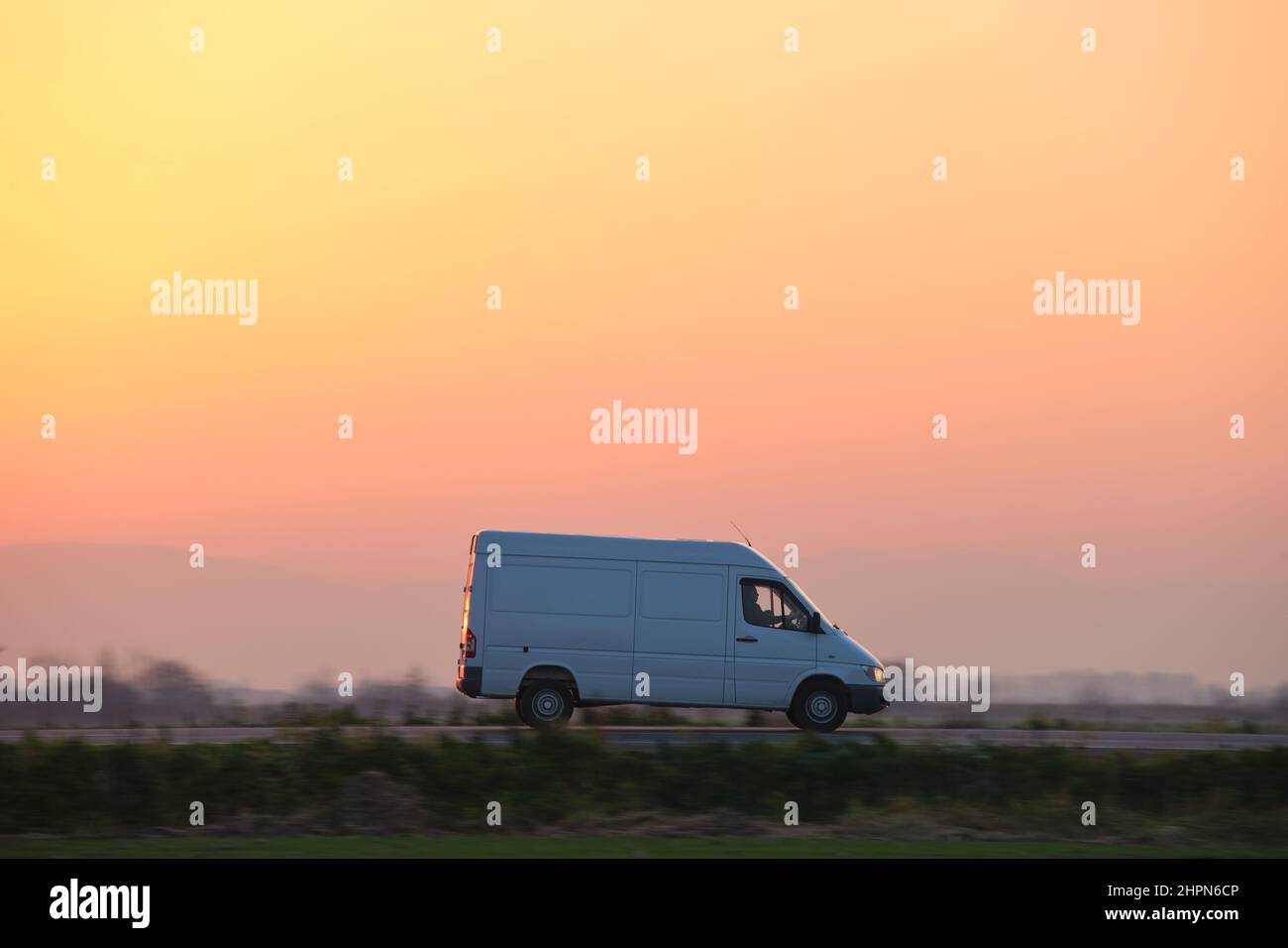 Small cargo van driving on highway hauling goods. Delivery ...