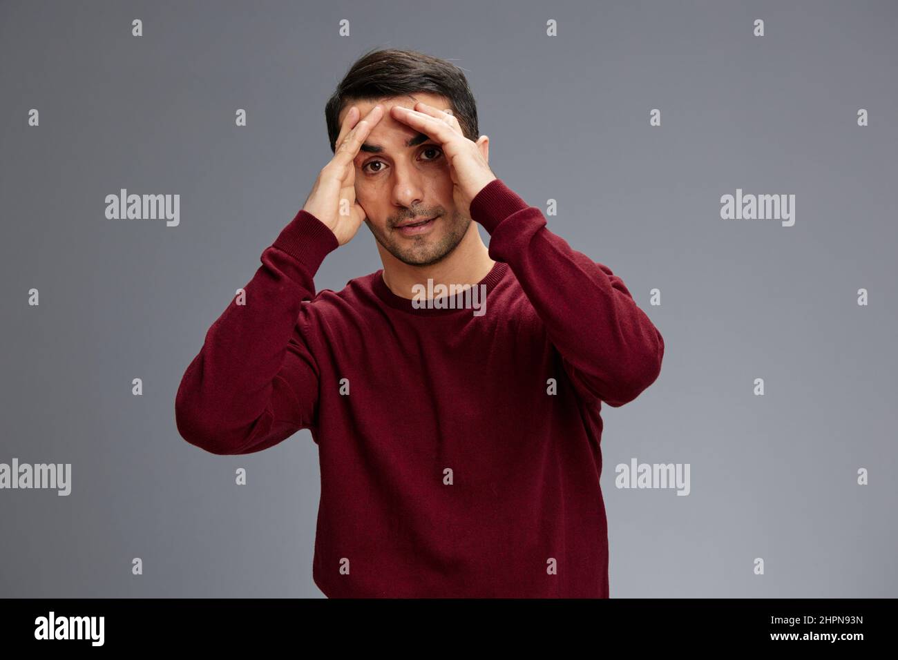 handsome man in a sweater posing hand gesture emotions Gray background ...