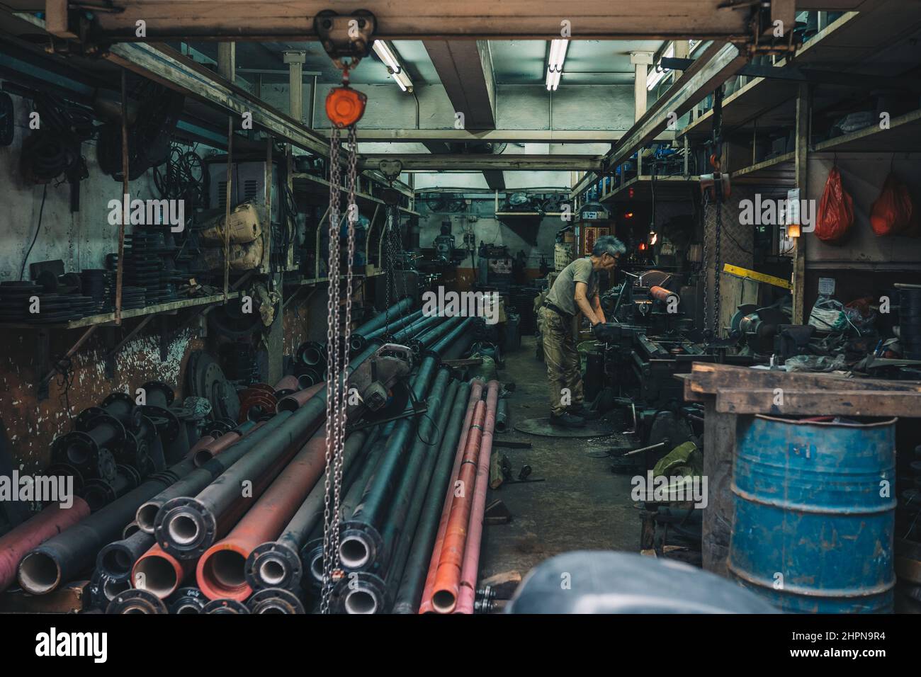 Mechanic at work in Hong Kong in a garage Stock Photo - Alamy