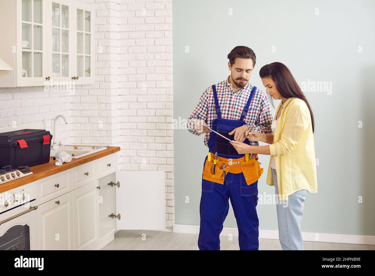 Male plumber consult female client about water pipes Stock Photo - Alamy