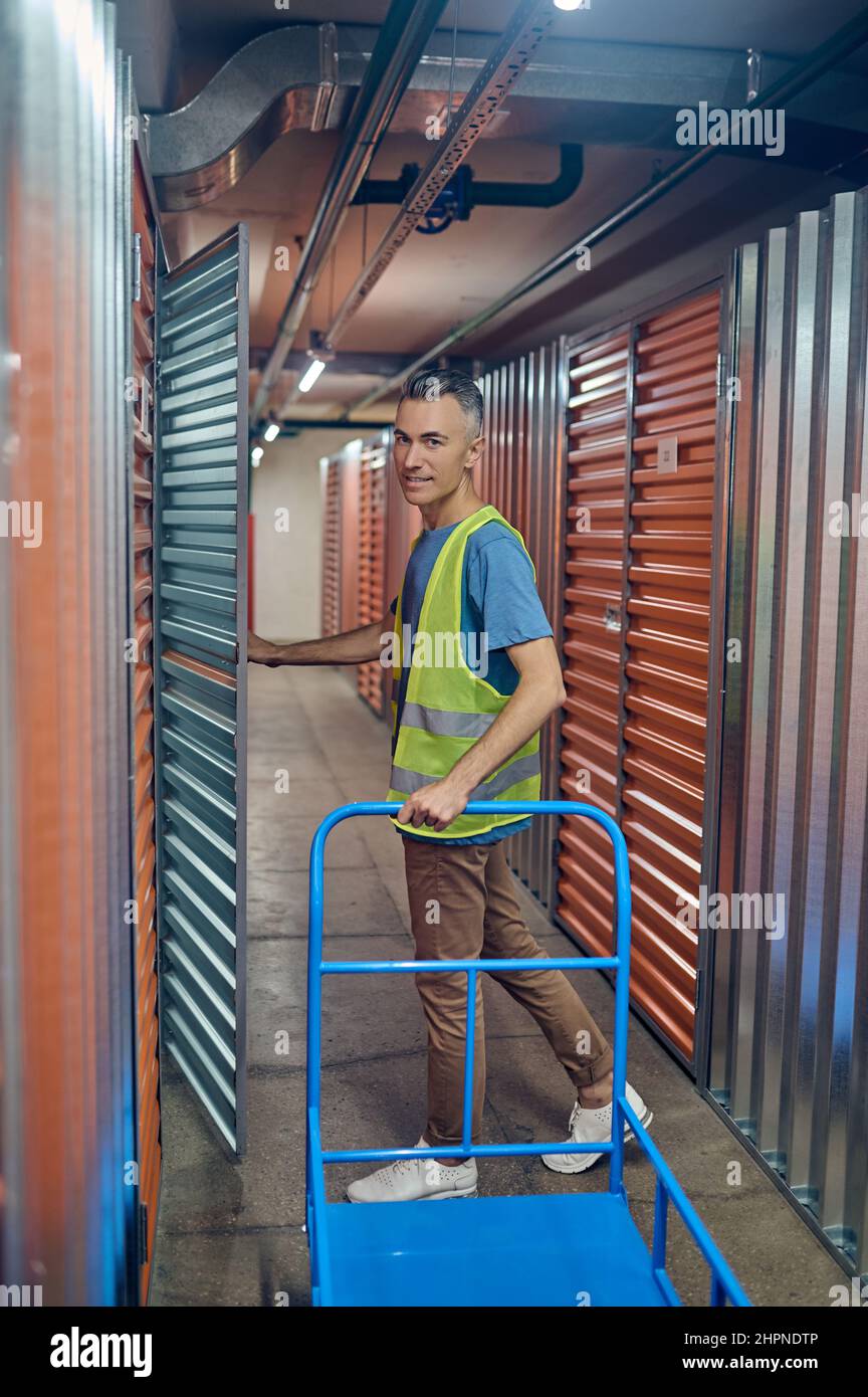 Contented warehouse worker posing for the camera at work Stock Photo ...