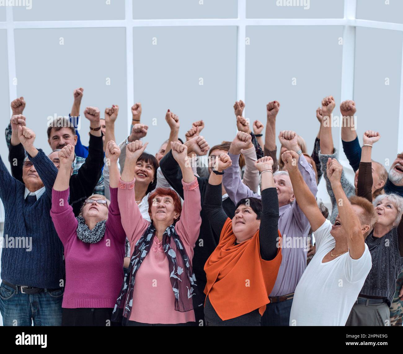 a group of elderly people raised their hands up Stock Photo - Alamy