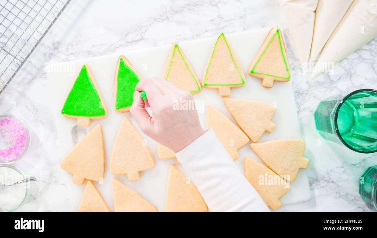 Flat lay. Stp by step. Icing Christmas tree-shaped sugar cookies with ...