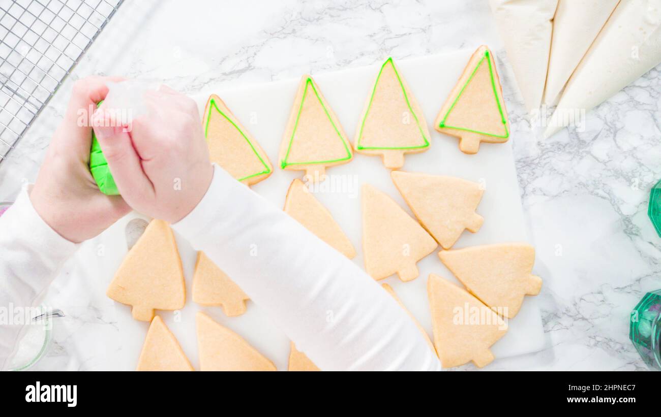 Flat lay. Stp by step. Icing Christmas tree-shaped sugar cookies with ...