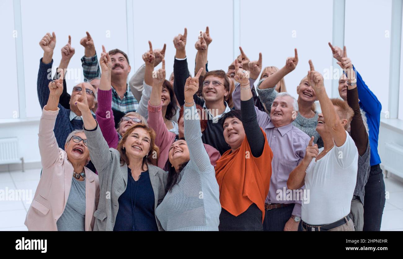 a group of older people raised their hands trying to reach Stock Photo ...