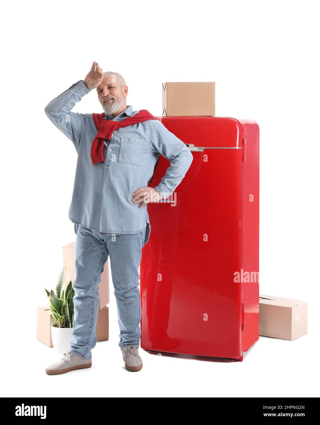 Tired mature man with moving boxes and red fridge on white background ...