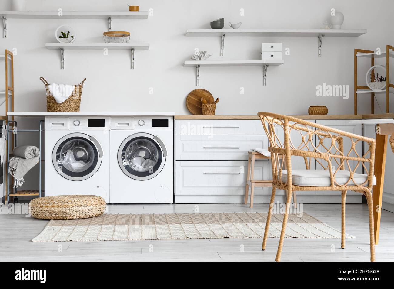 Interior of light kitchen with washing machines, laundry basket and ...