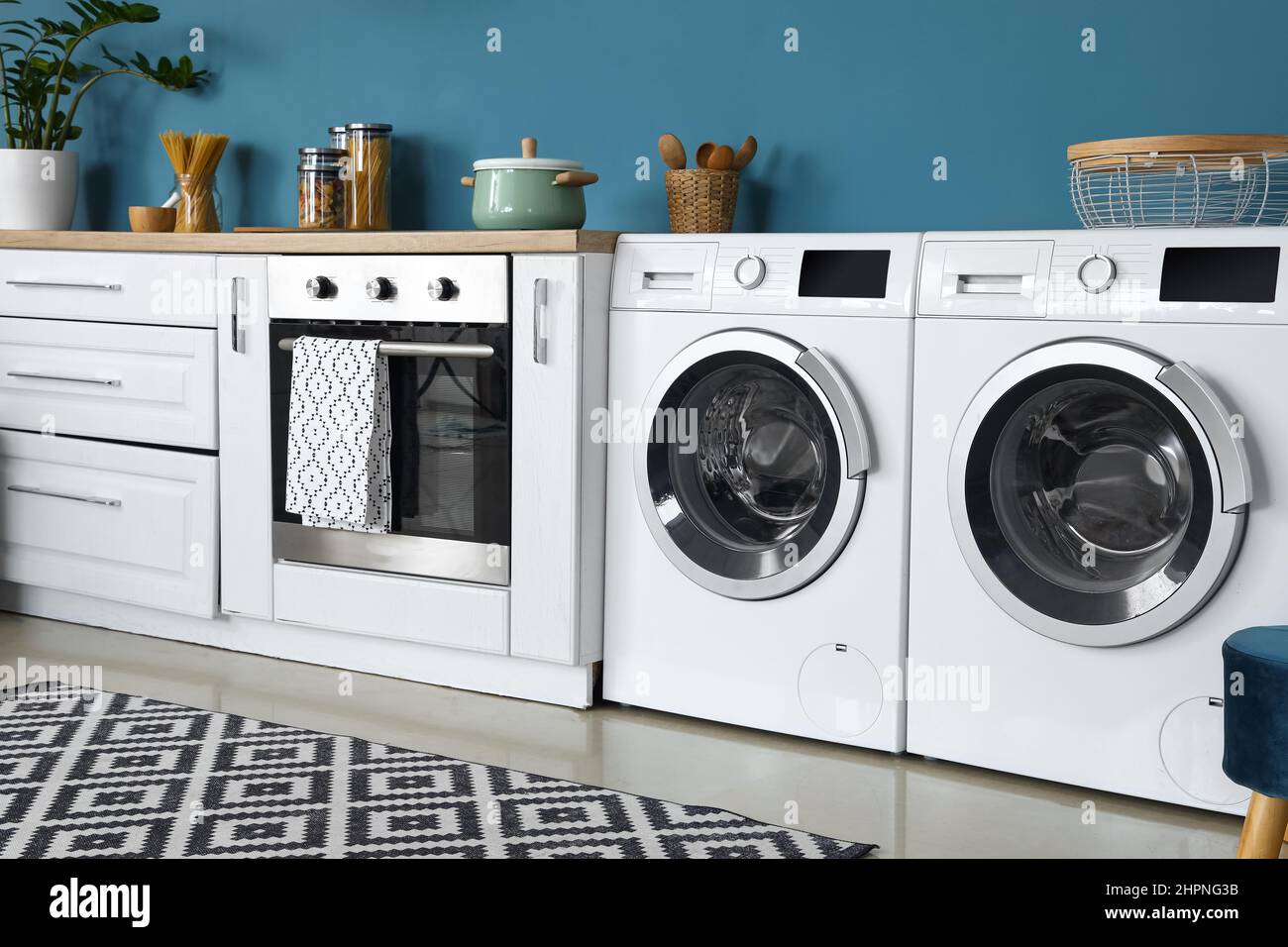 Interior of stylish kitchen with modern washing machines, oven and ...