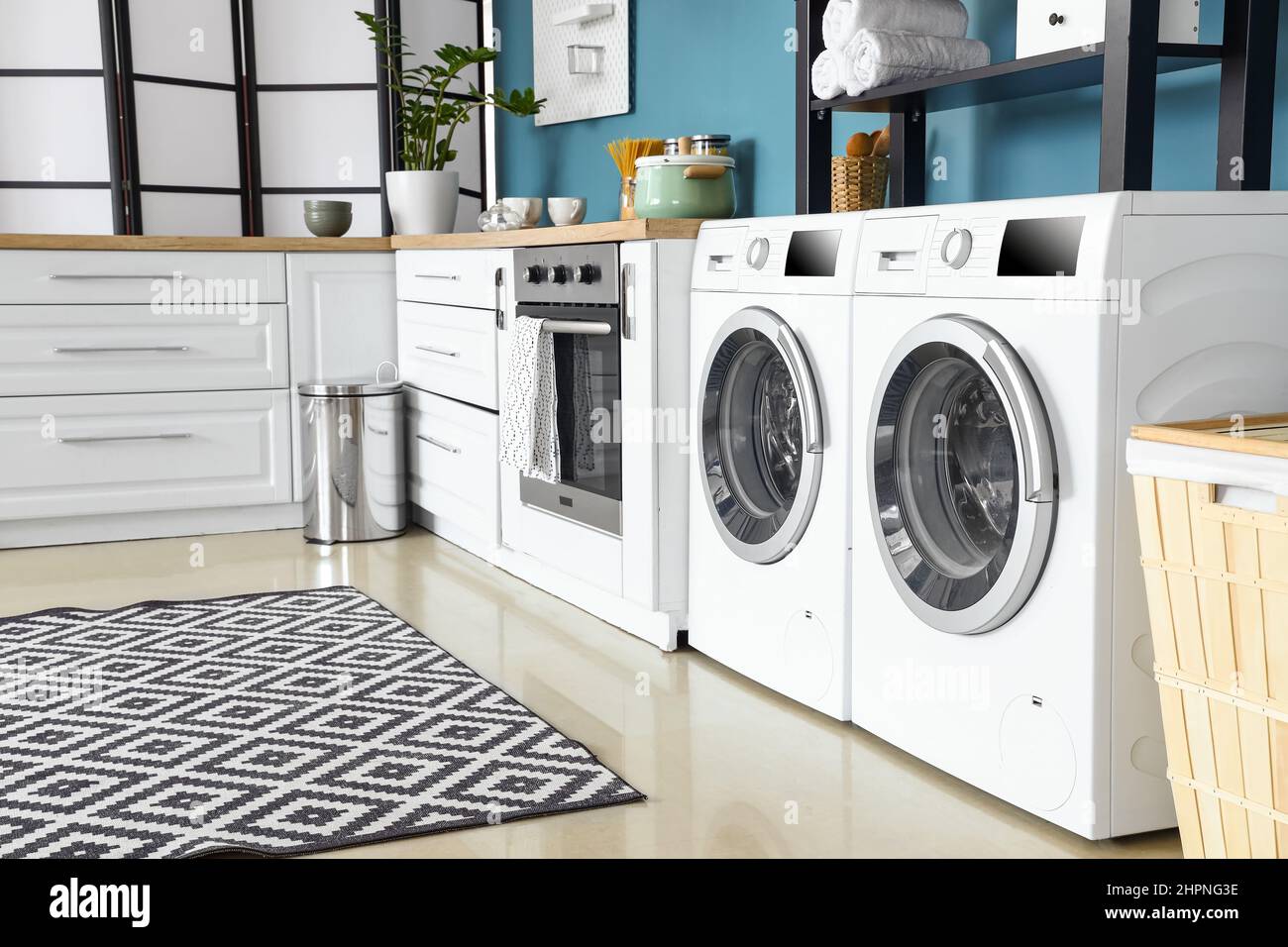 Interior of stylish kitchen with modern washing machines, oven and ...