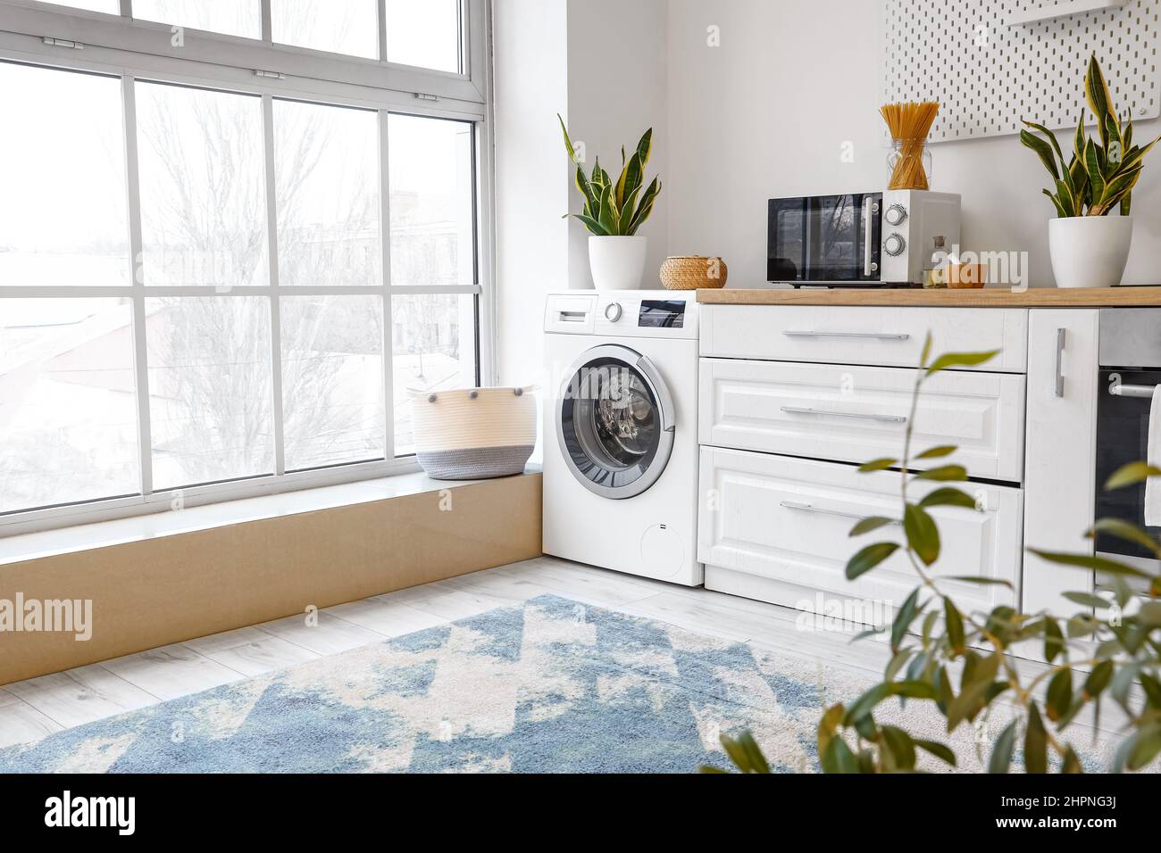 Interior of modern kitchen with washing machine and white counter Stock ...