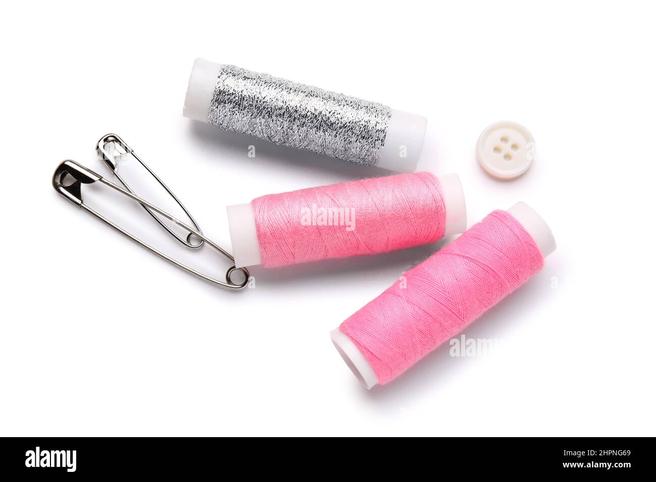 Thread spools with button and pins on white background Stock Photo - Alamy