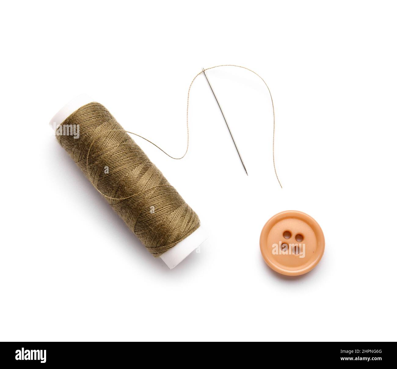 Thread spools with button and needle on white background Stock Photo ...