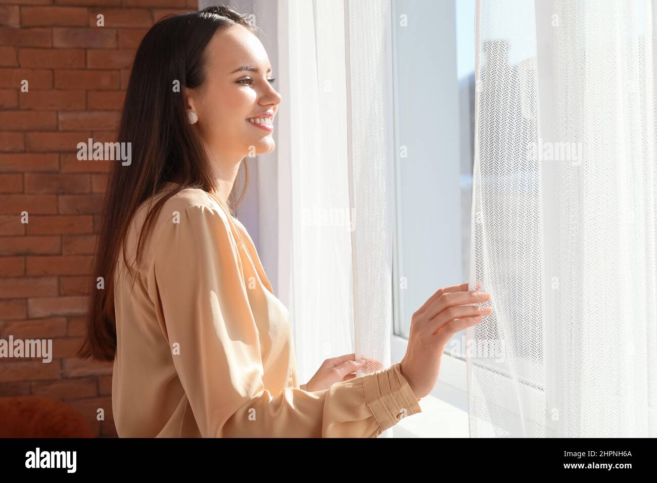 Pretty young woman near window Stock Photo - Alamy