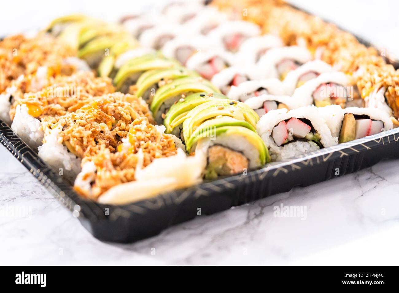 Pre-packaged variety of sushi and sushi rolls in a plastic tray Stock ...