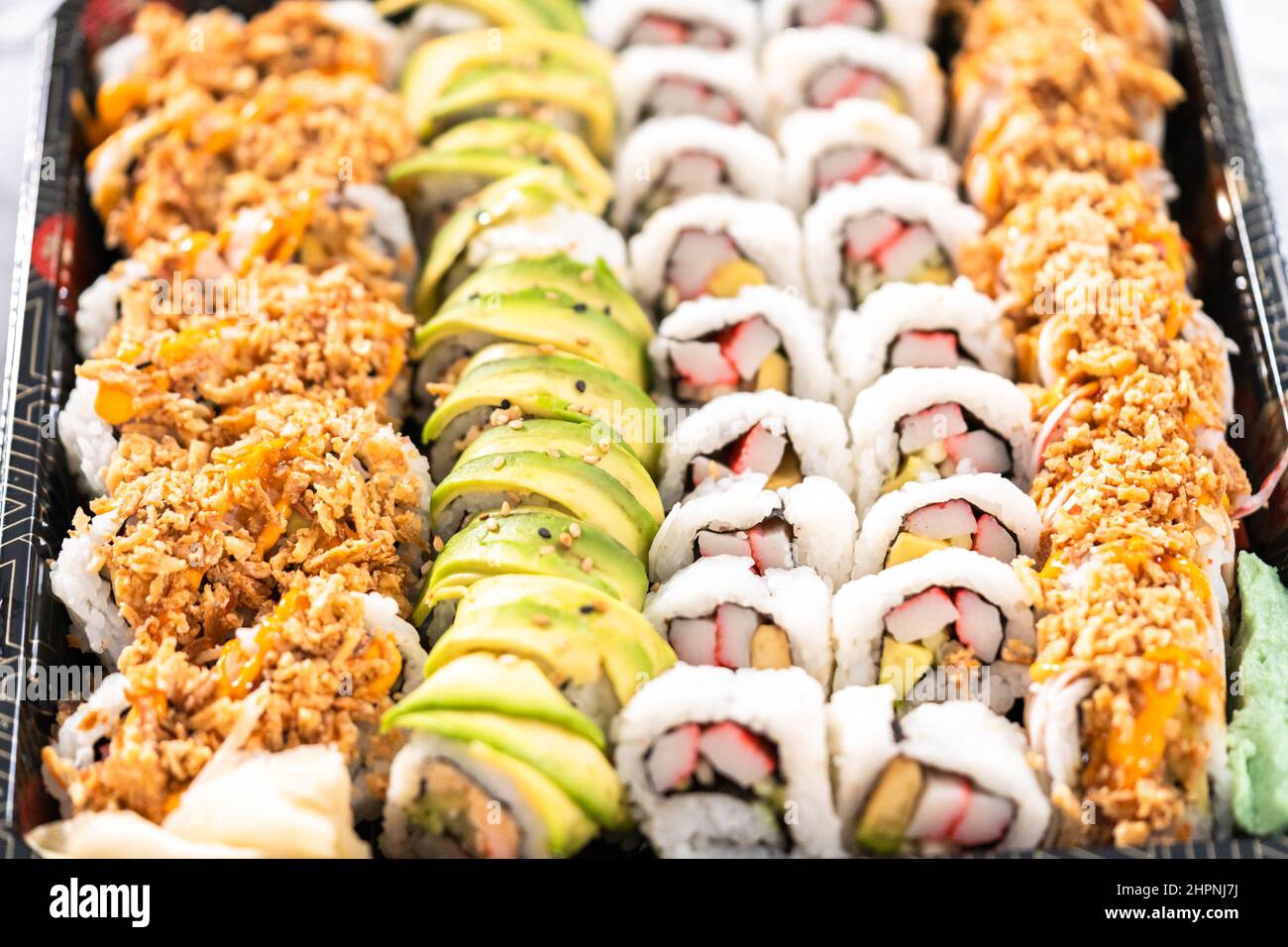 Pre-packaged variety of sushi and sushi rolls in a plastic tray Stock ...