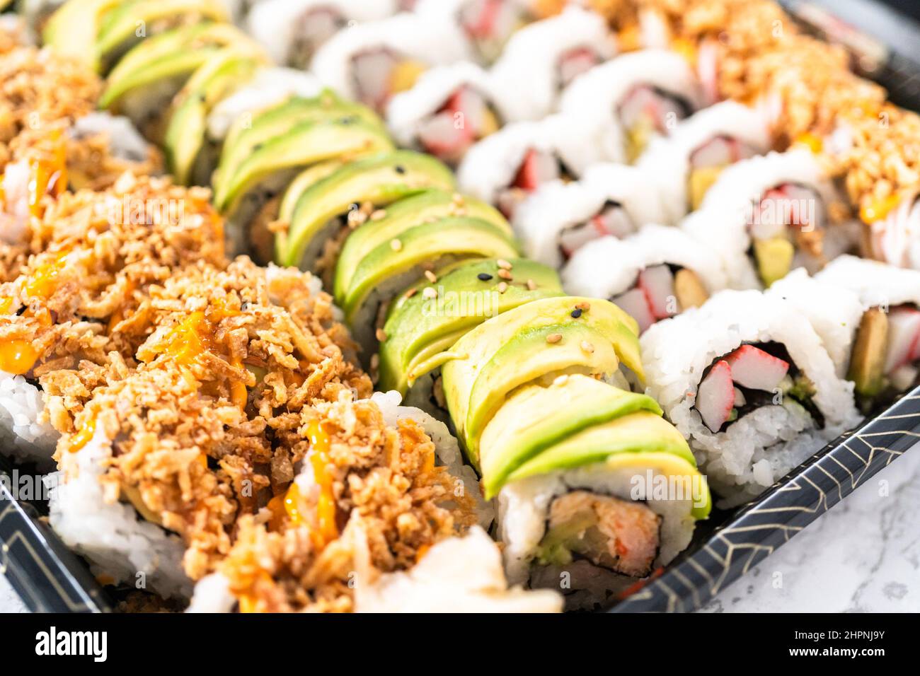 Pre-packaged variety of sushi and sushi rolls in a plastic tray Stock ...