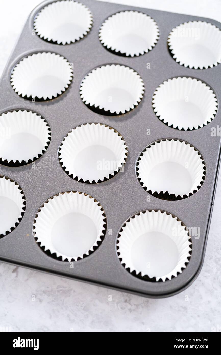 Lining cupcake baking pan with foil cupcake liners to bake unicorn ...