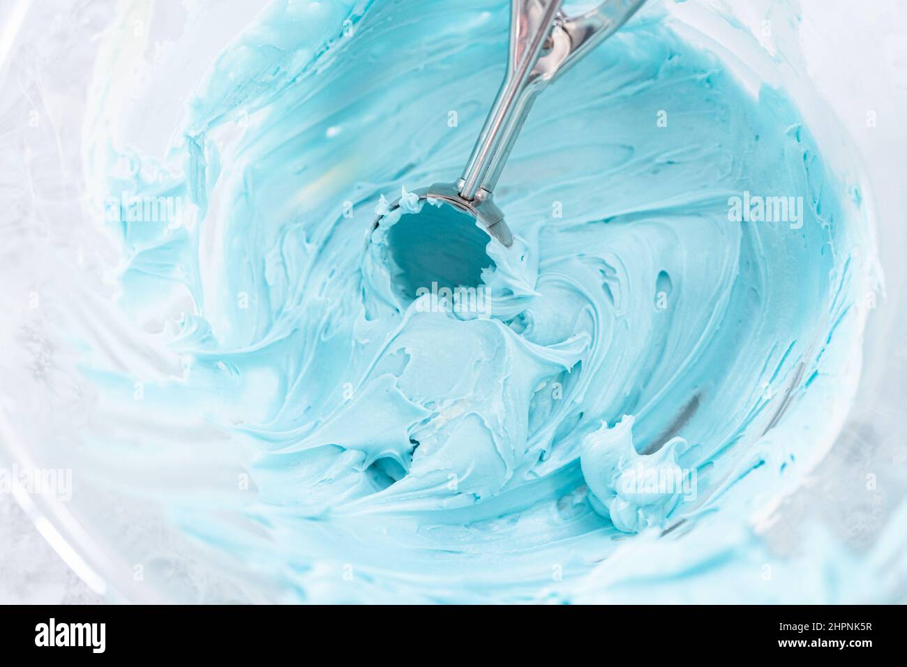 Mixing in blue food coloring into the buttercream frosting Stock Photo ...